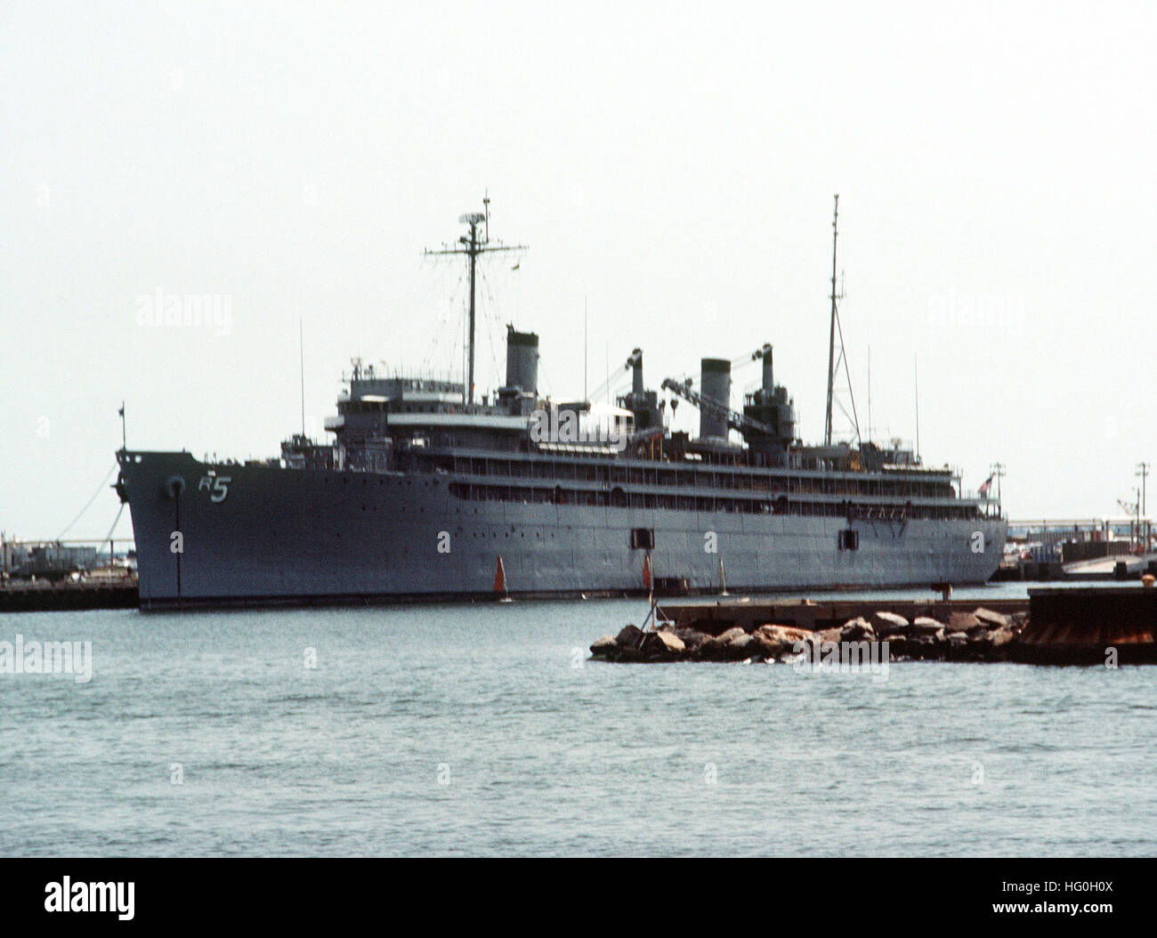 A port bow view of the repair ship USS VULCAN (AR 5) moored to pier ...