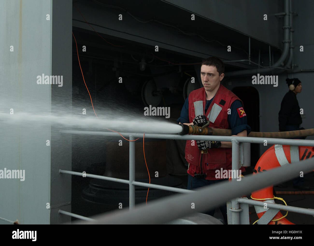 Gunner's Mate 3rd Class Joseph Quartararo discharges water overboard as ...