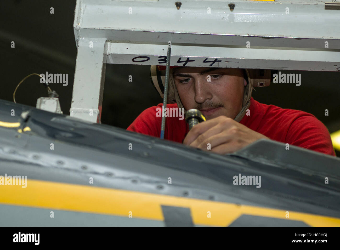 Aviation Ordnanceman installs a hoist on F/A-18F Super Hornet aboard ...
