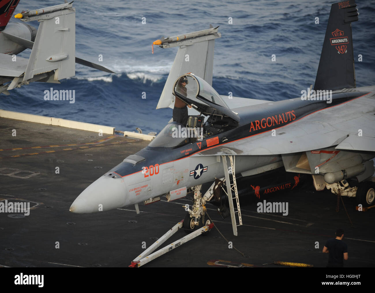 A plane captain washes a window of an F/A-18E Super Hornet from the ...