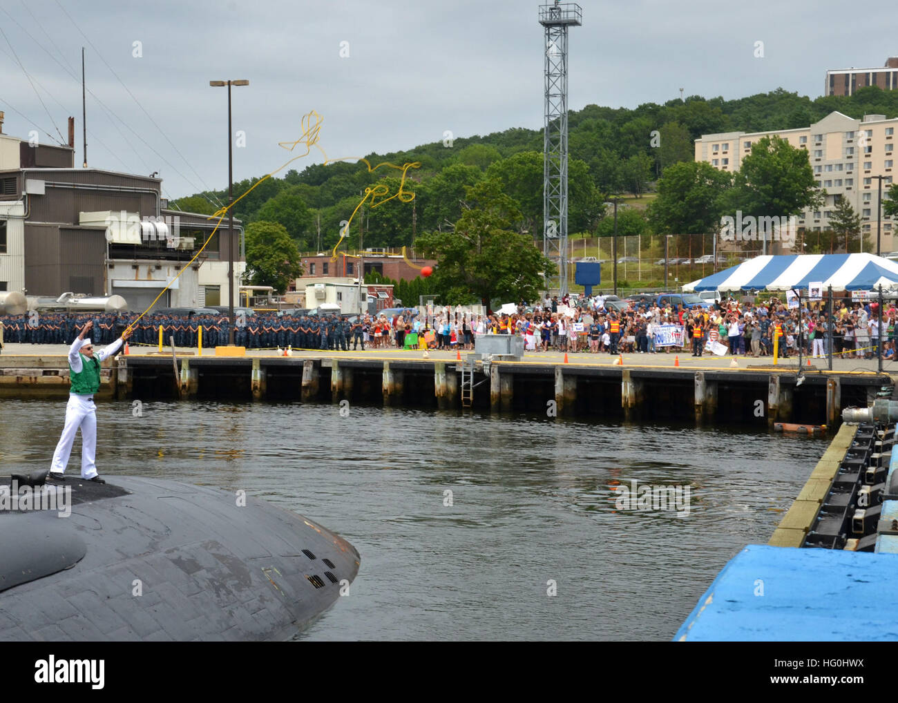 A USS Springfield (SSN 761) sailor casts the first line to the pier as ...