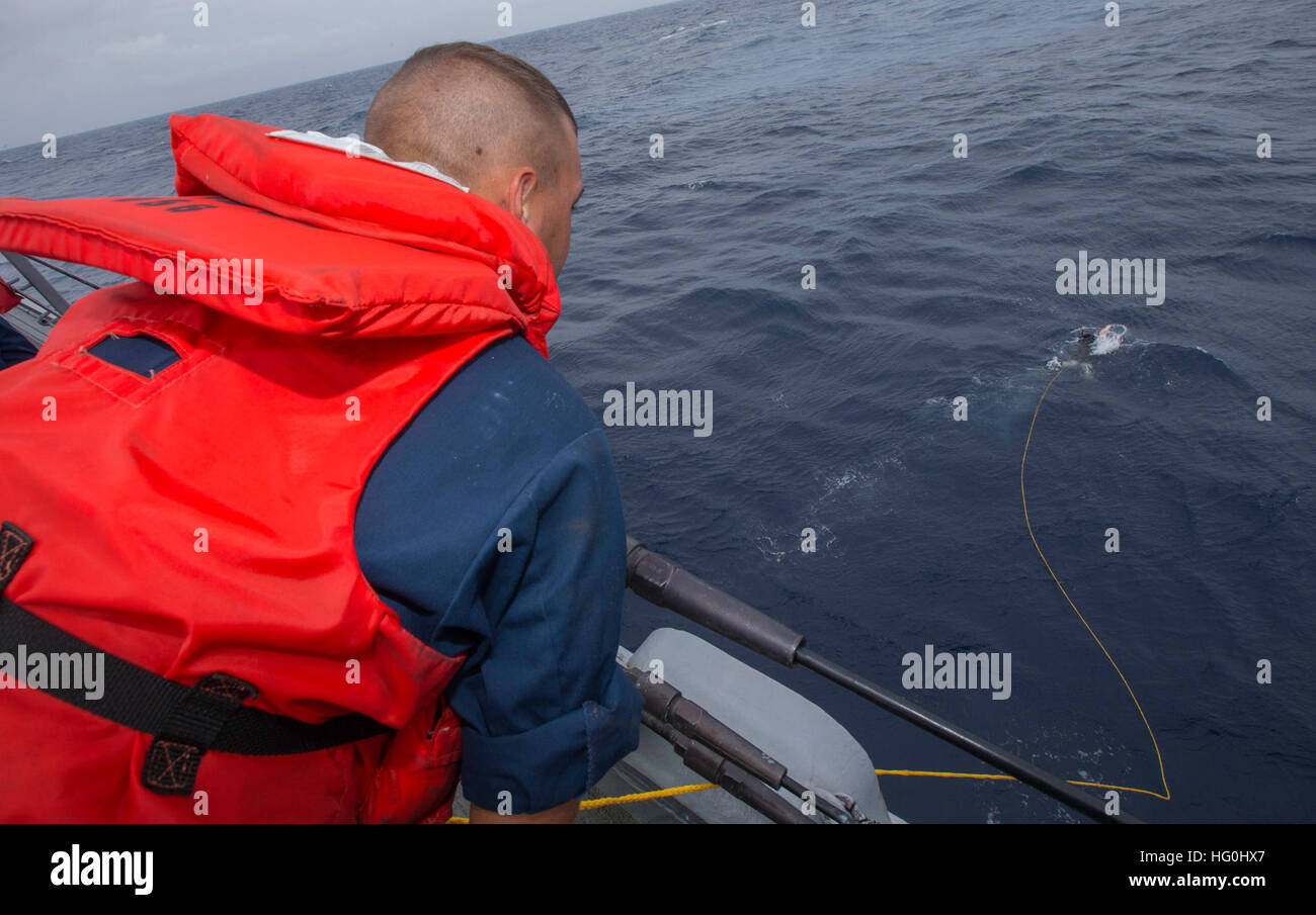 U.S. Navy Boatswain?s Mate 3rd Class Craig Drey tends a safety line ...