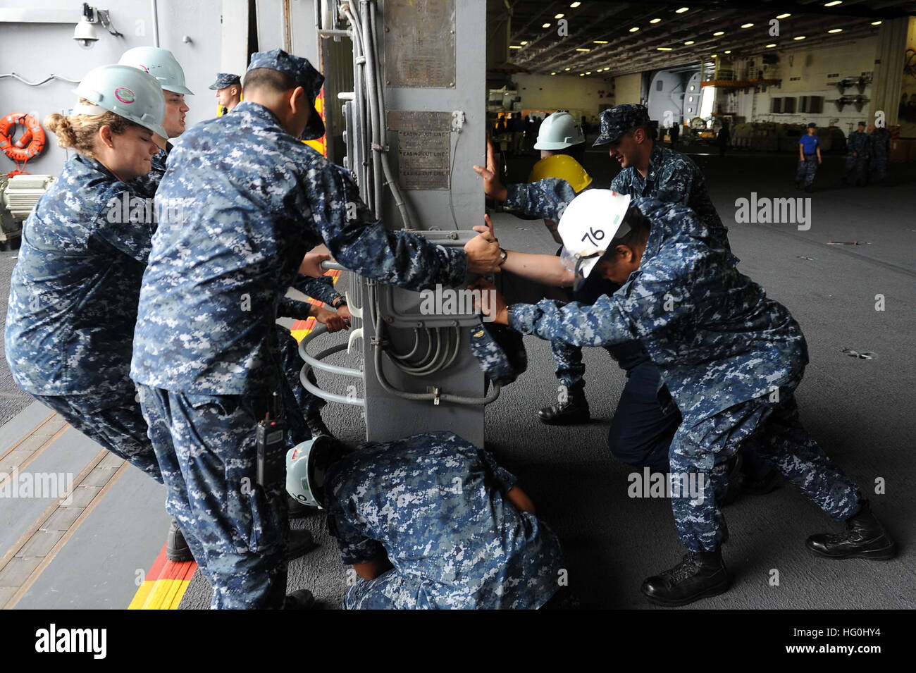 Deck department sailors maneuver a sliding pad eye into position for ...