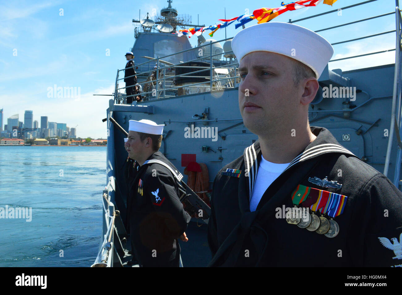 With a fully dressed ship and streamers, U.S. Navy sailors assigned to ...