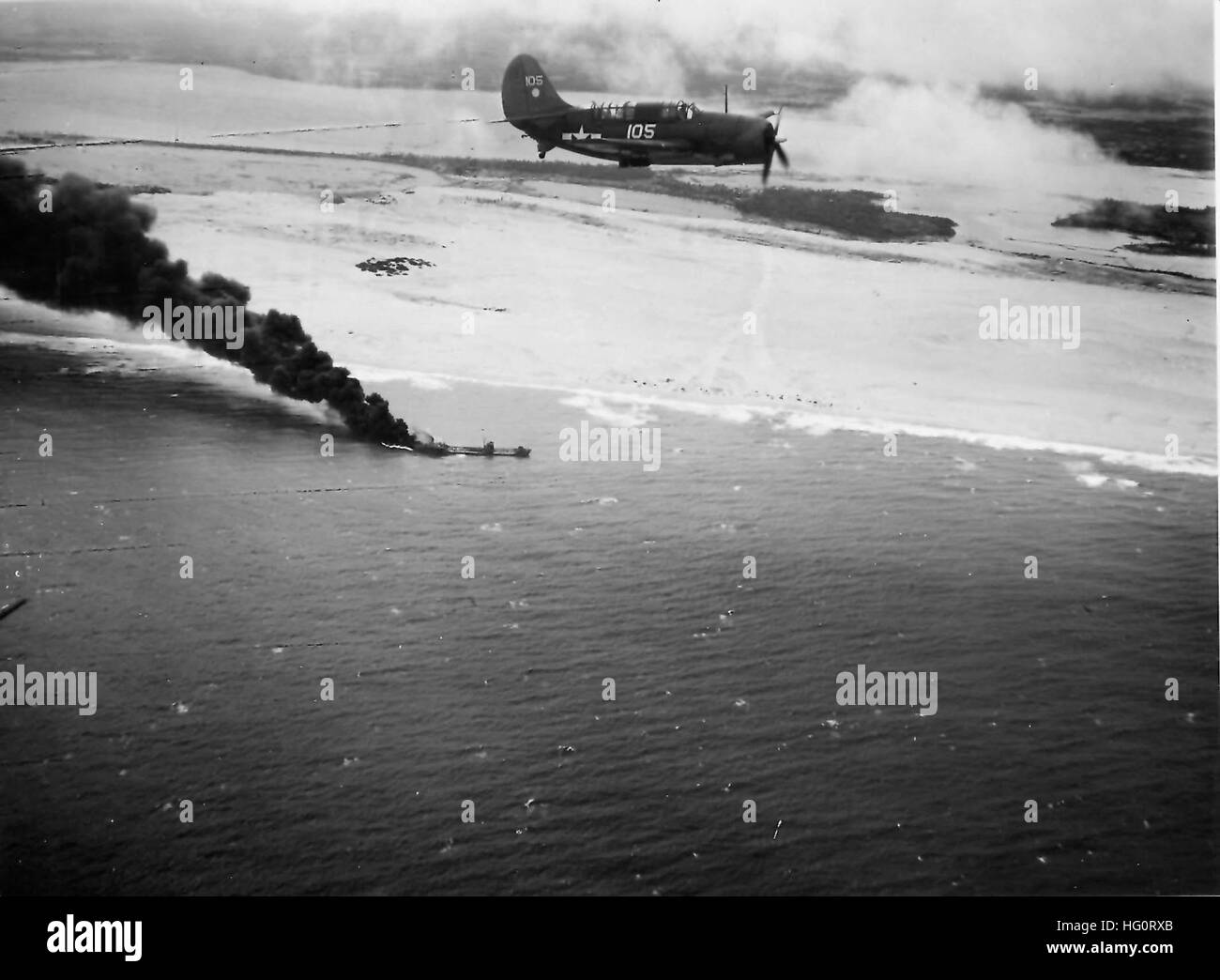 US Navy Helldiver flying over a burning Japanese tanker January 1945 ...