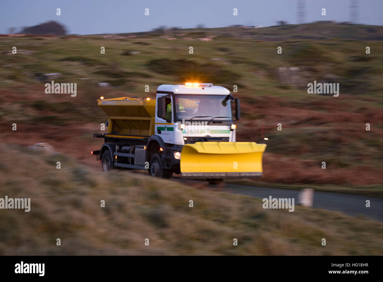 A Flintshire gritting vehicle passes over Halkyn Mountain blurred by ...
