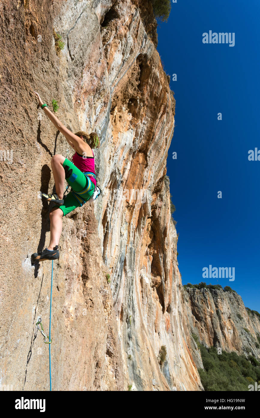 Body of female extreme Climber stepping up on high vertical Rock Stock ...