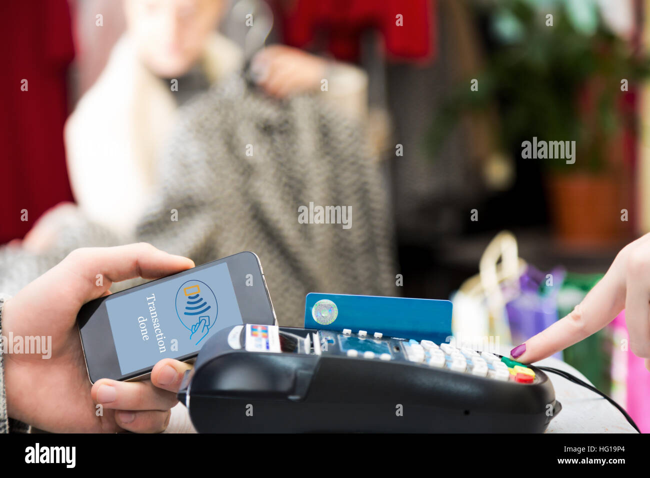 Man completing mobile Payment at Store Cashiers Desk with Terminal ...