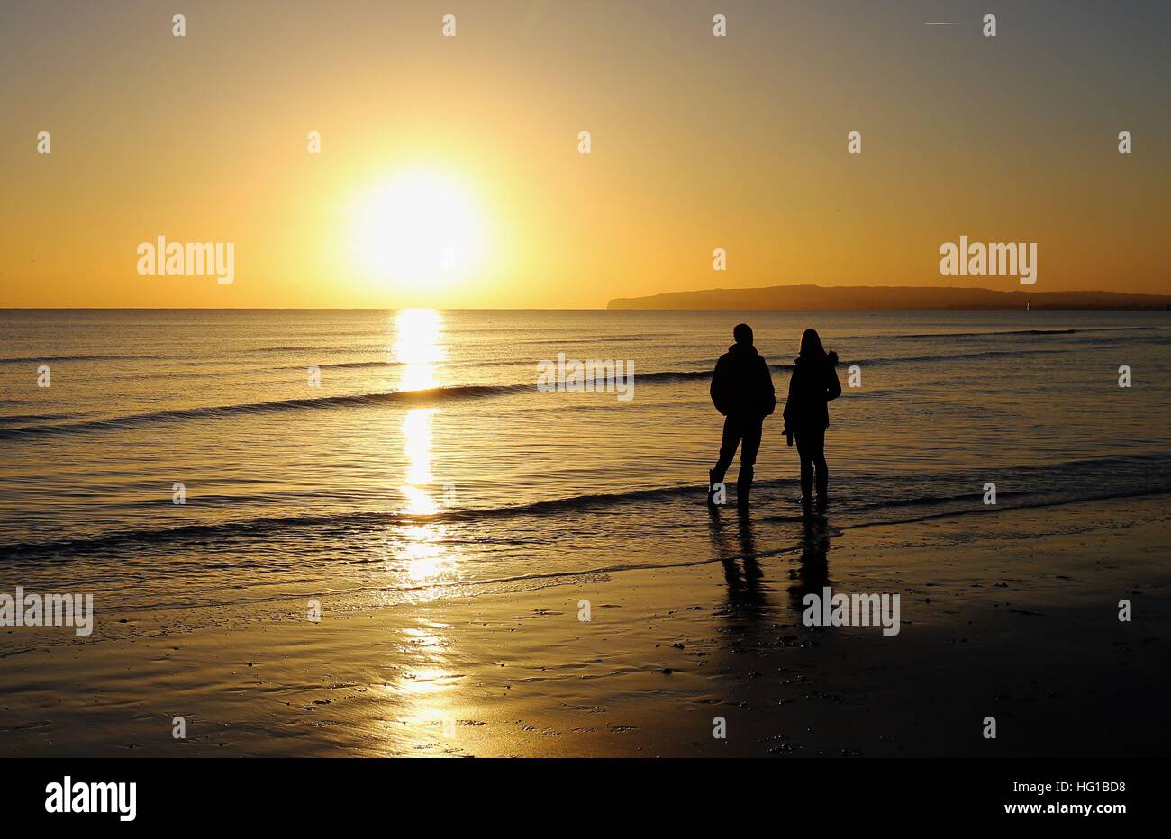 People watch the sun set on the beach in Camber, East Sussex, as parts ...