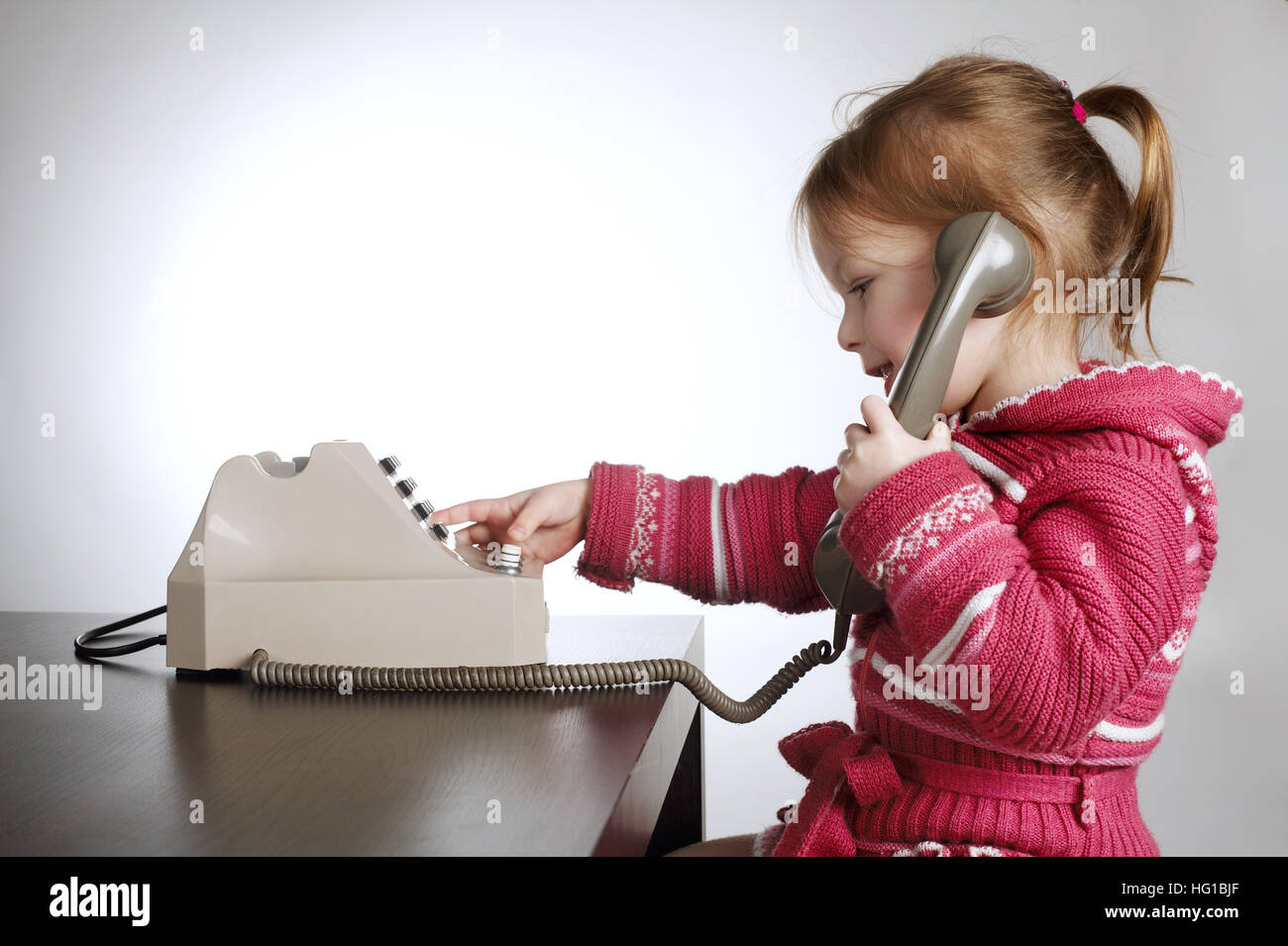 little girl using old phone Stock Photo - Alamy