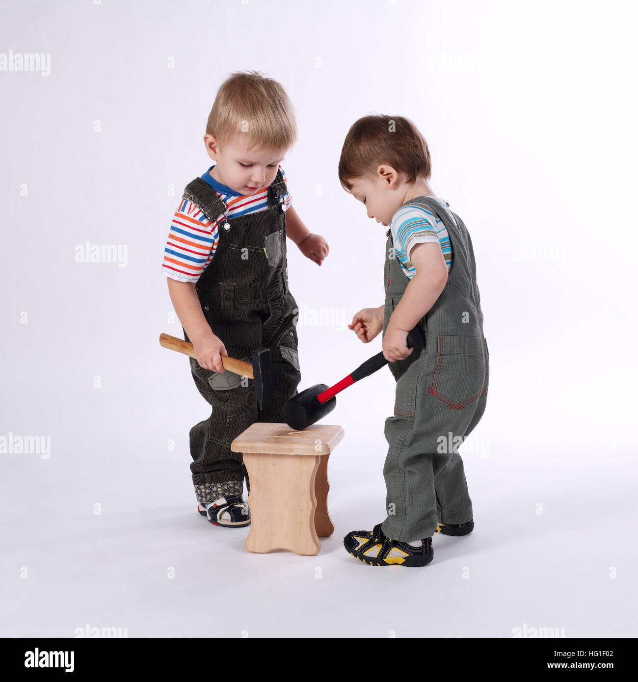 two little boys repairing chair on white Stock Photo - Alamy