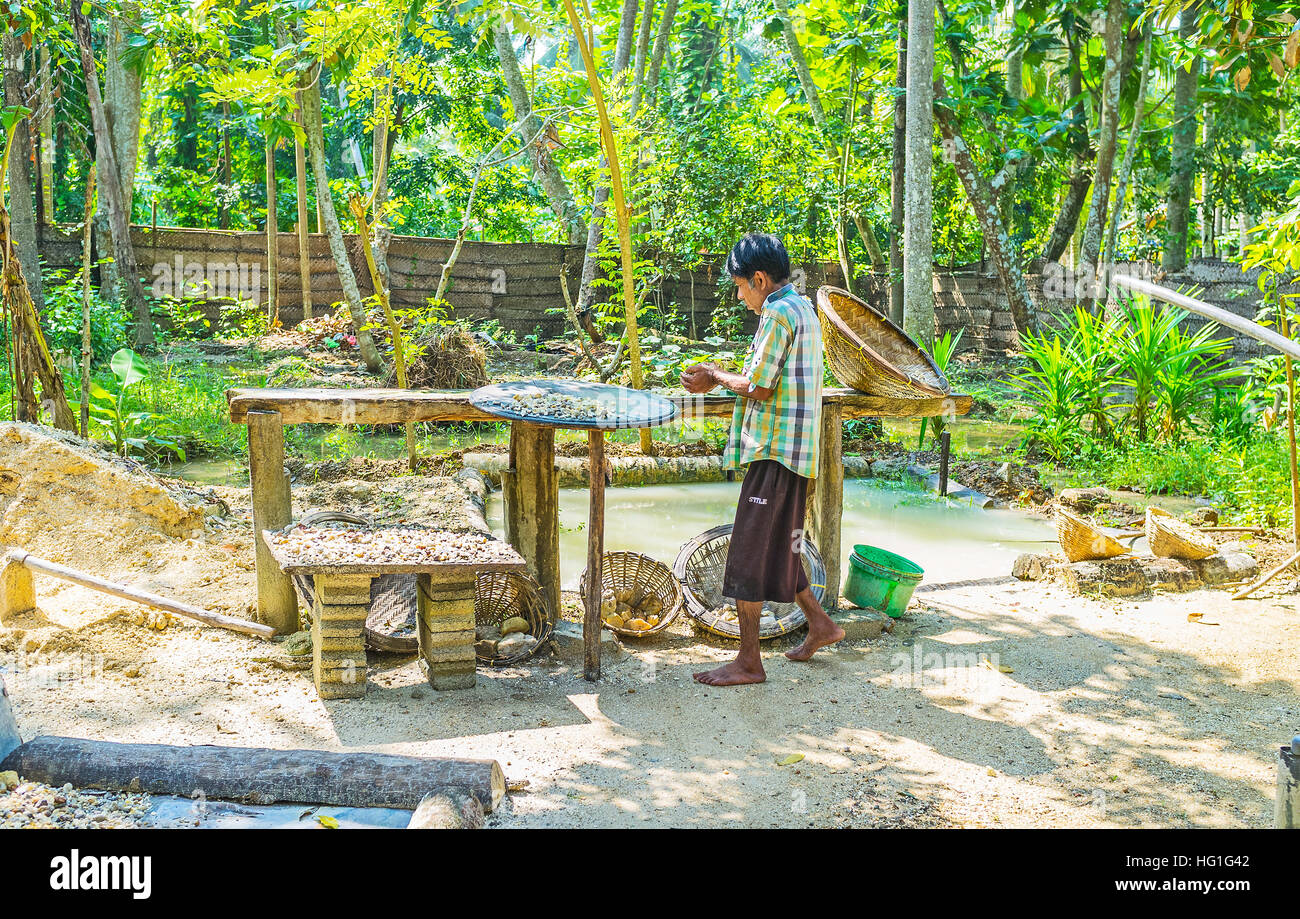 The worker of moonstone mine at his working place - washes and filters ...
