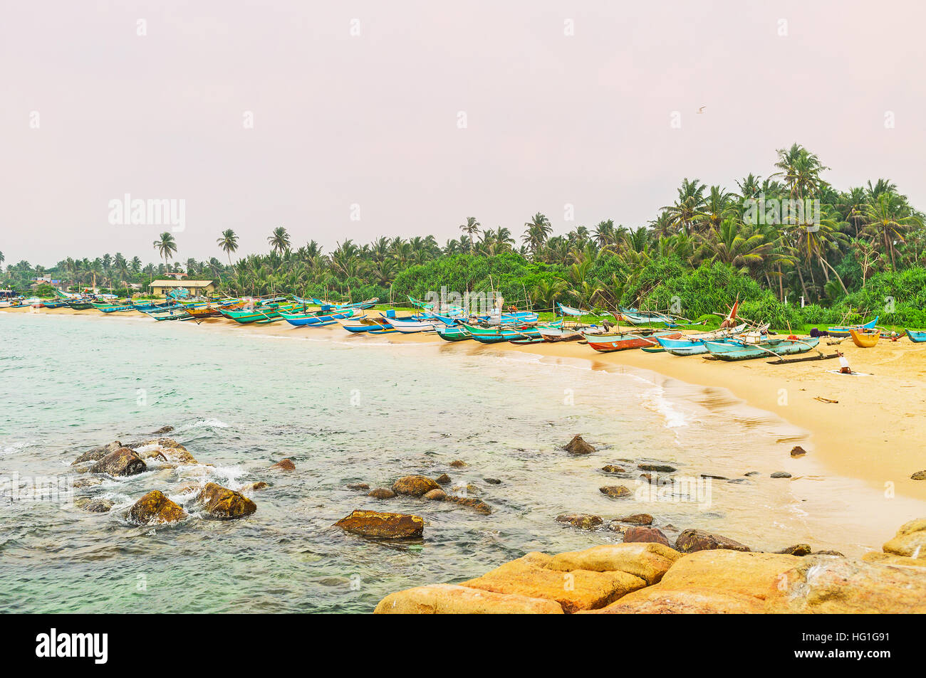 The evening view of the ocean's shore with the old catamaran boats and ...