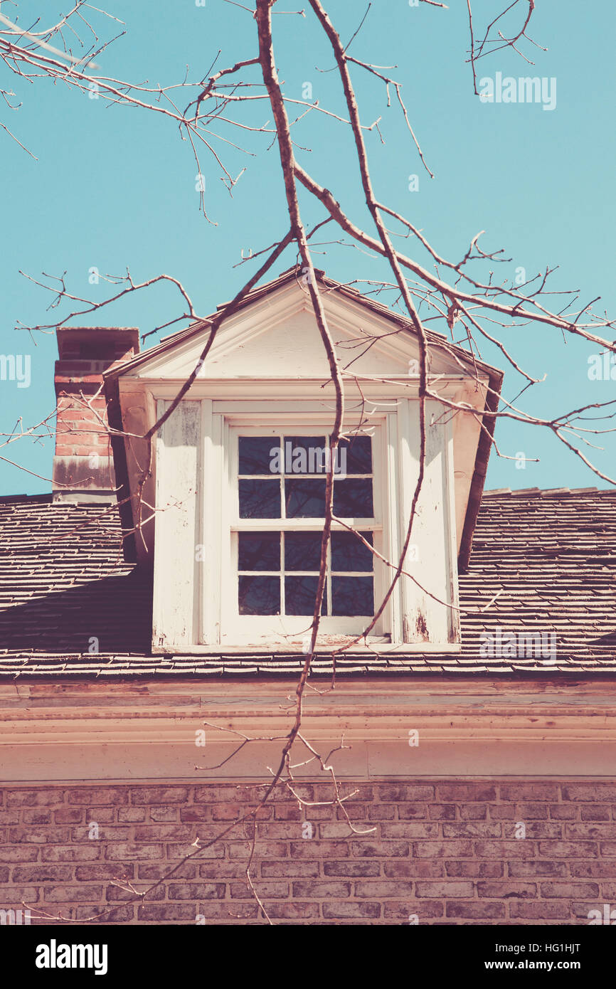 An old window is seen through barren tree branches Stock Photo - Alamy