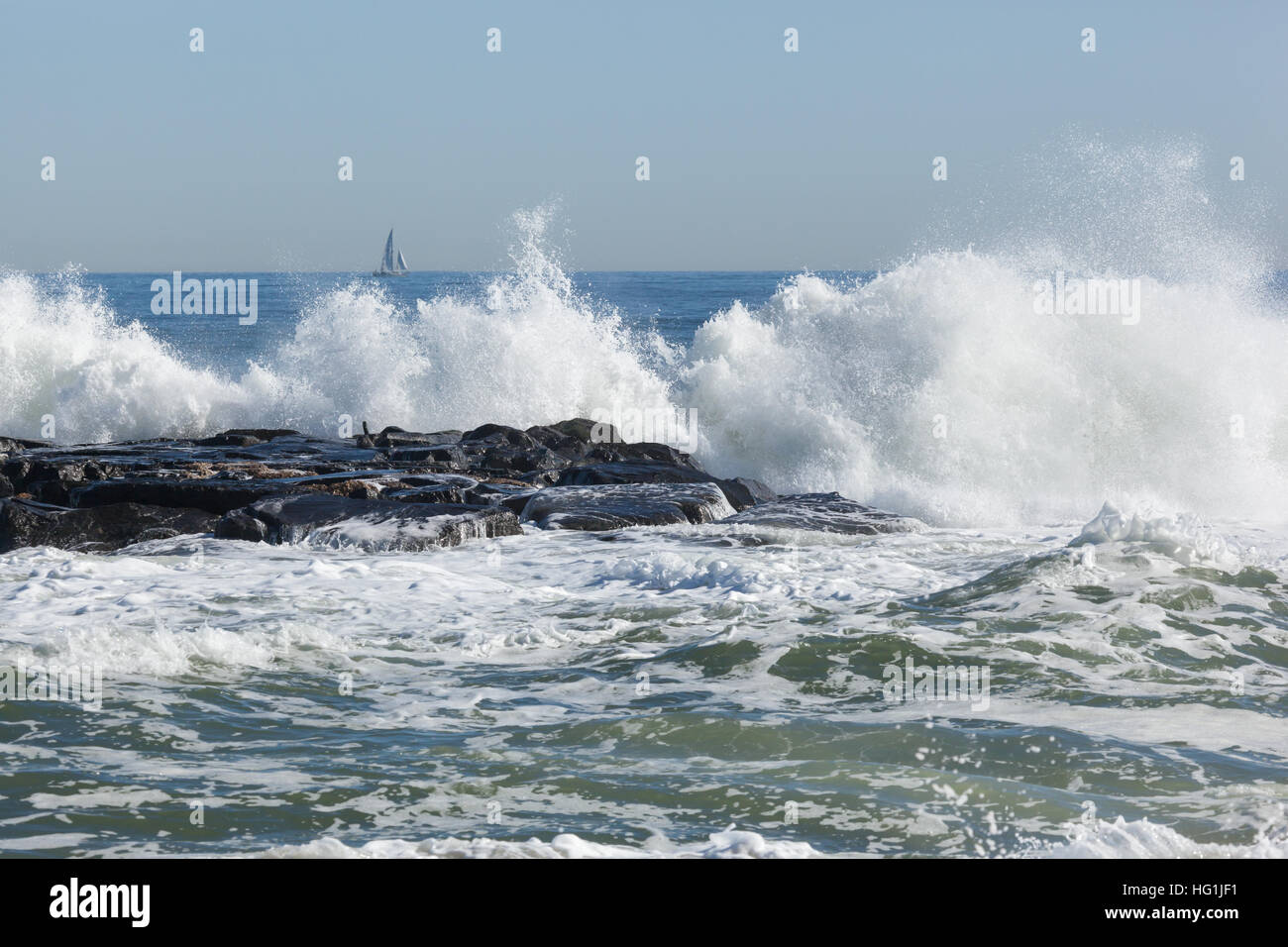 Waves crash over the jetty in Asbury Park, New Jersey on a crisp fall ...