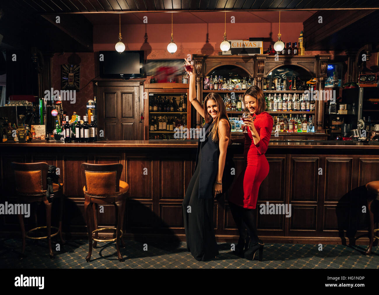two beautiful women are relaxing in the bar,two young woman near a bar ...