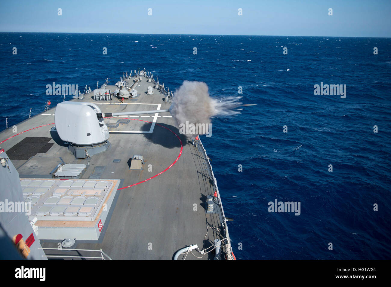 A round is fired from an MK45 5-inch gun during a live-fire exercise ...