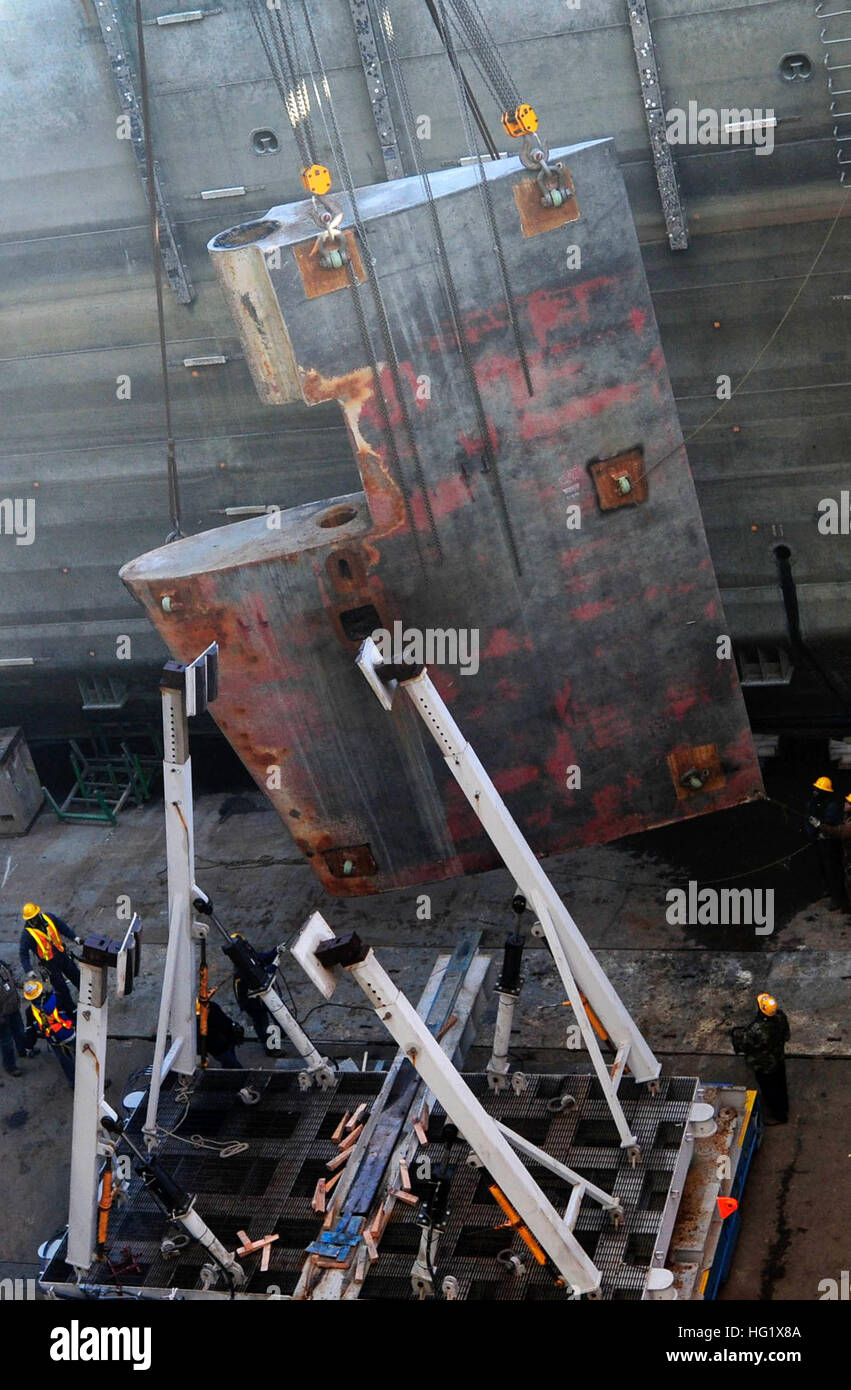 Shipyard workers remove the port rudder from the aircraft carrier USS ...