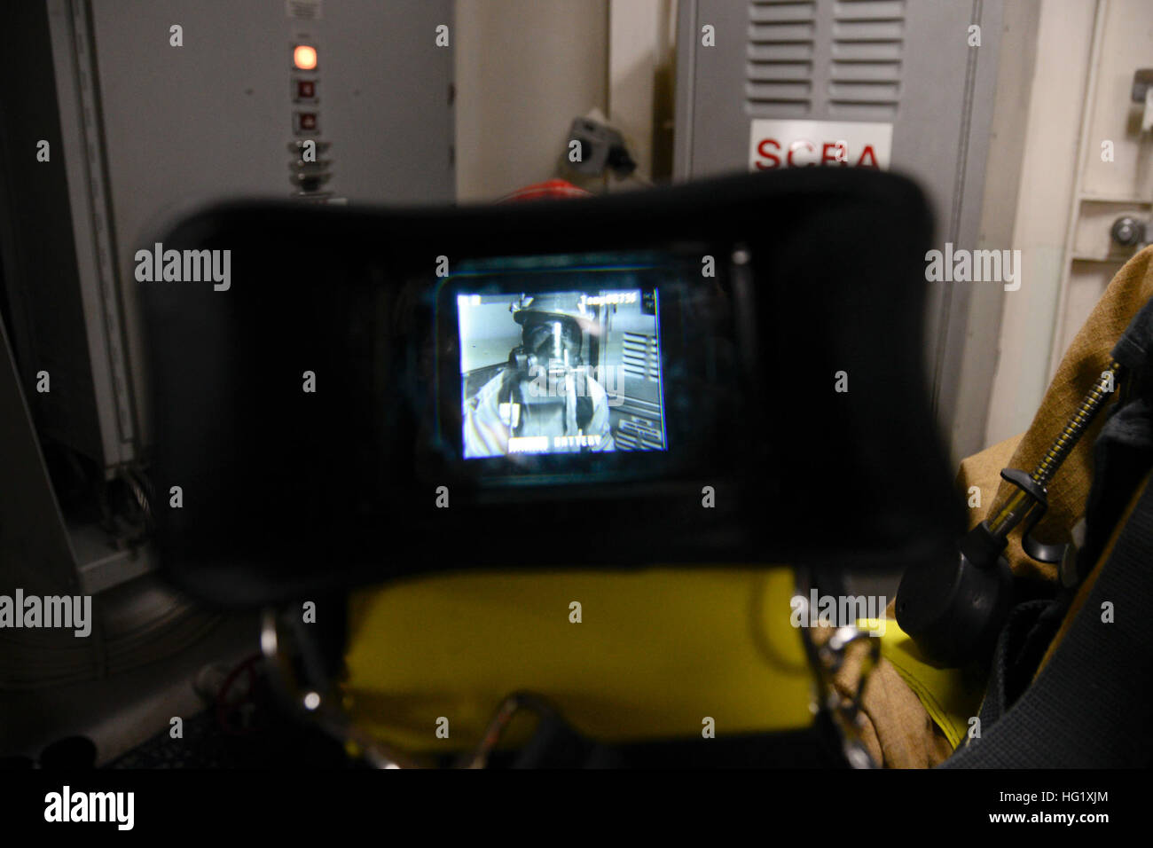 U.S. Navy Fireman Jevon Smith is visible through a naval firefighting ...