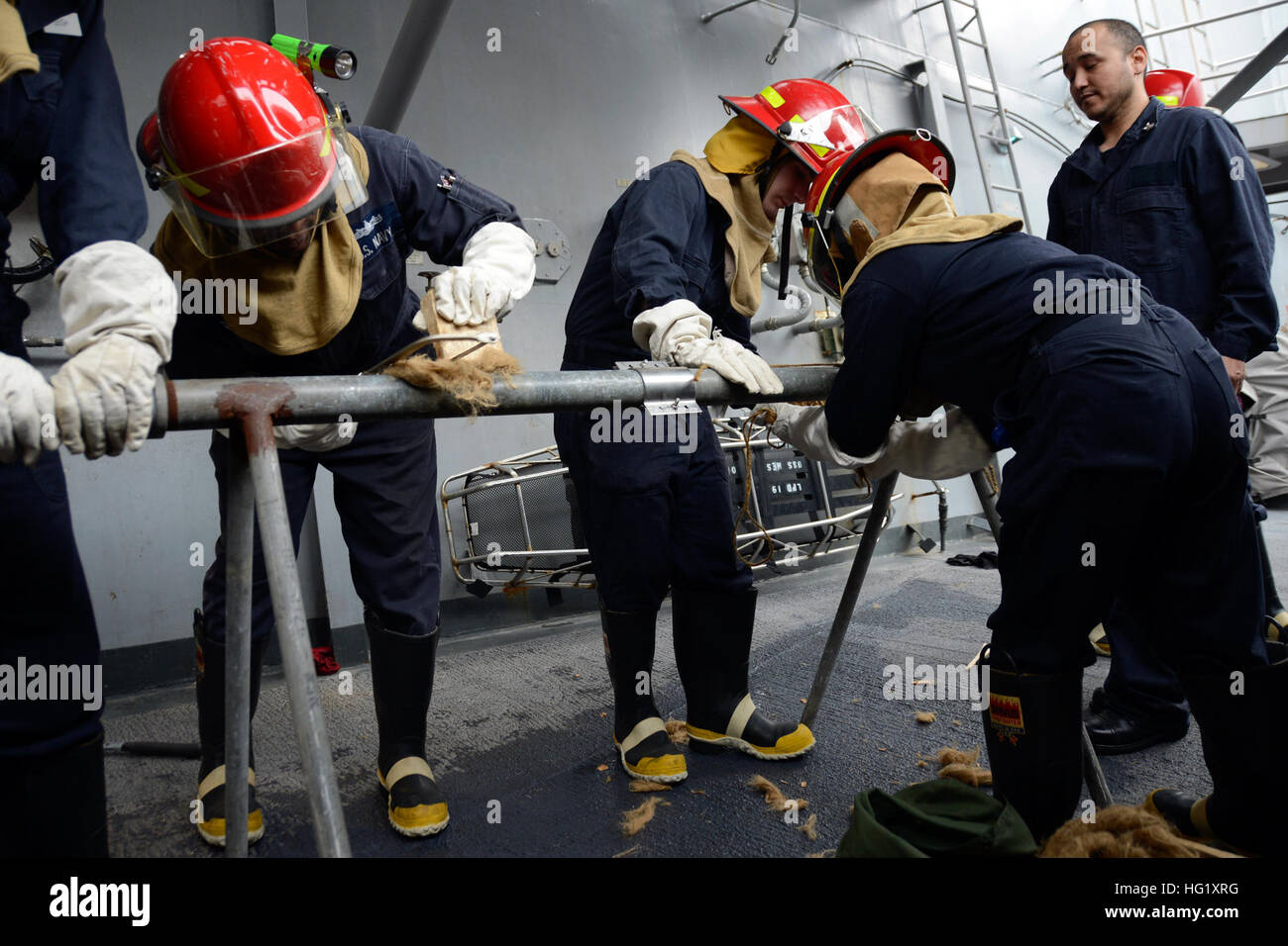 Sailors practice various pipe patches during a simulated flooding drill ...