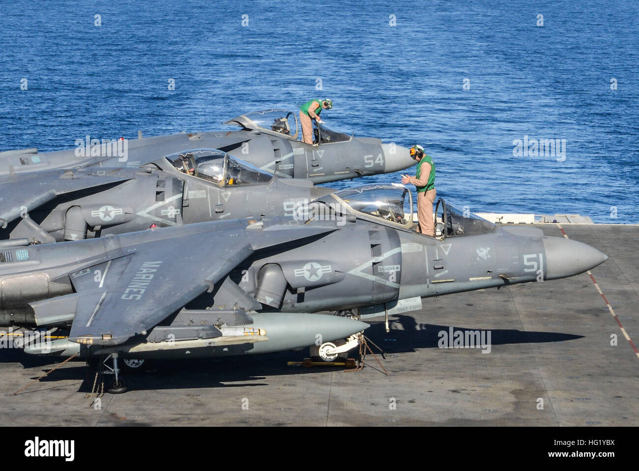 Marine plane captains inspect their AV-8B Harriers on the flight deck ...