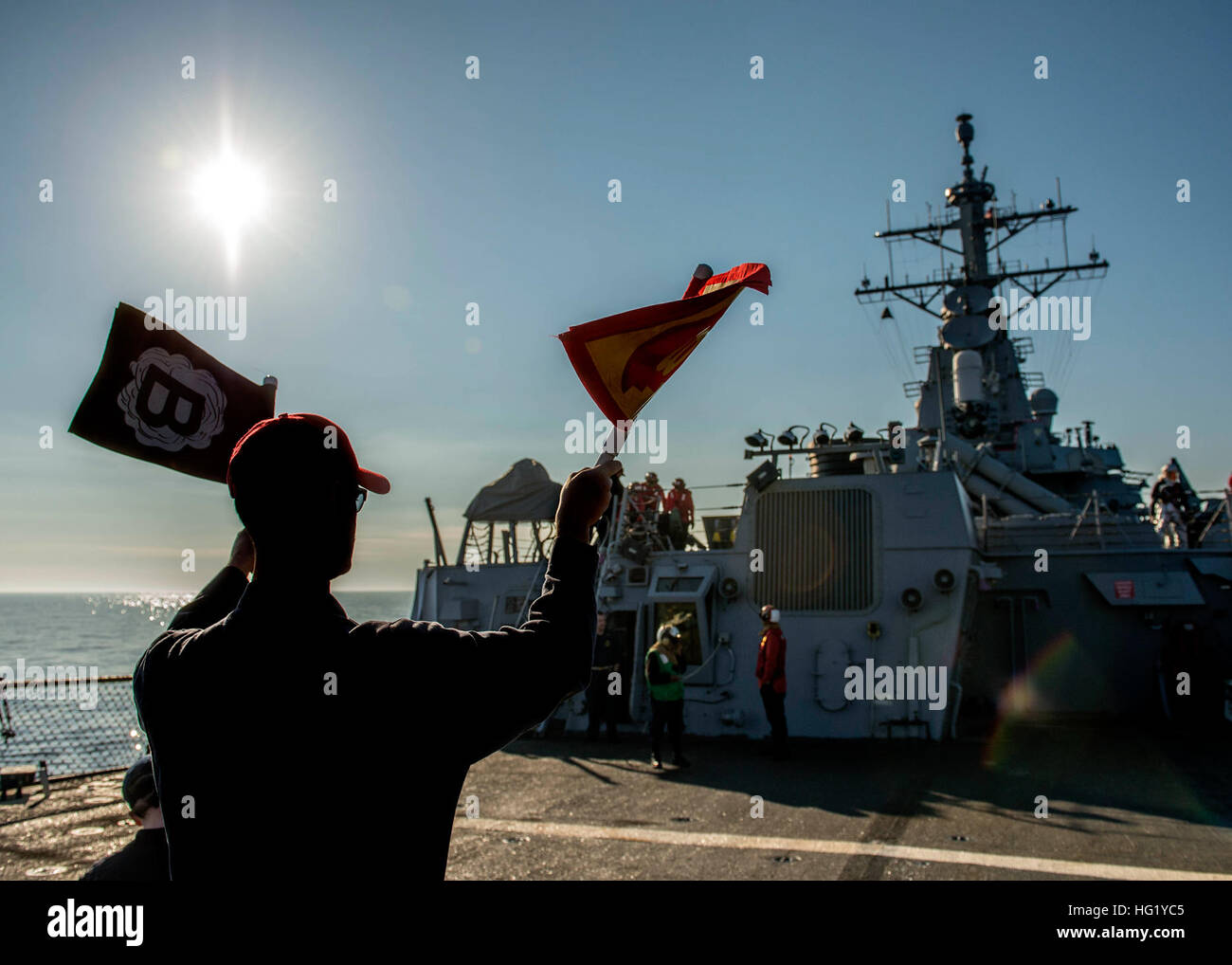 U.S. Navy Chief Hull Maintenance Technician Jonathan Fitzgerald signals ...