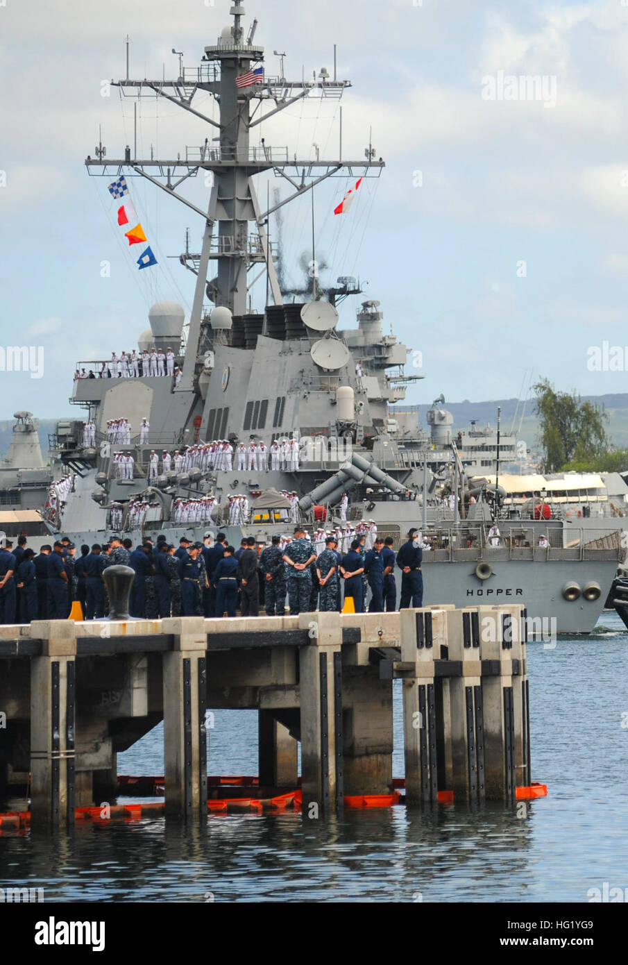 U.S. Sailors watch from ashore as the guided missile destroyer USS ...