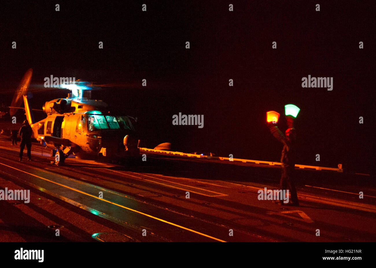U.S. Navy Aviation Structural Mechanic 3rd Class Robert Detzel signals ...