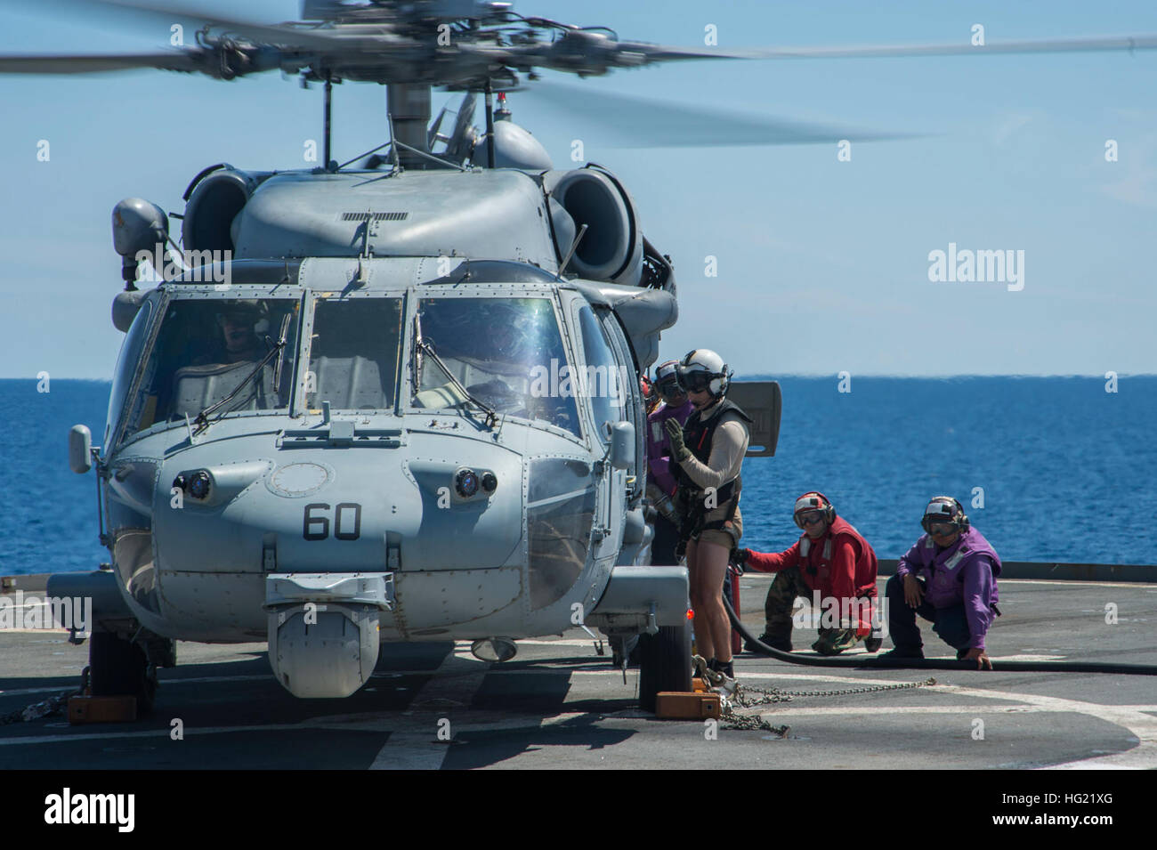 Sailors refuel an MH-60S Sea Hawk helicopter, assigned to Helicopter ...