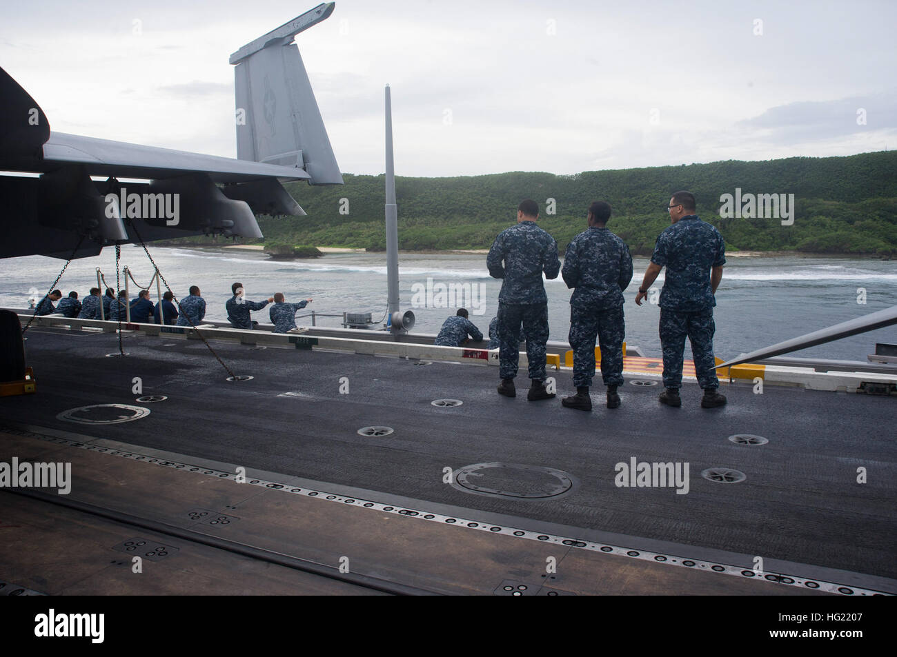 U.S. Sailors observe Guam from the flight deck of the aircraft carrier ...
