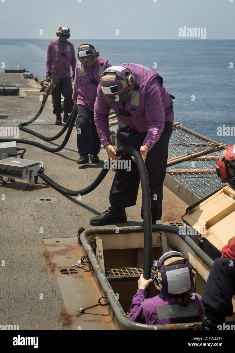 Sailors stow a refueling probe after refueling a helicopter on the ...