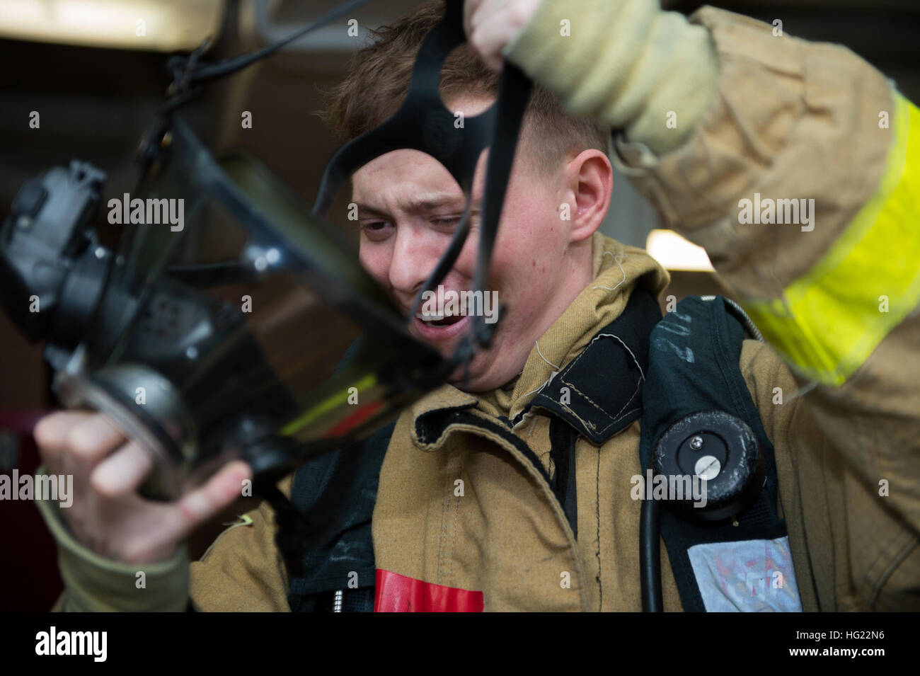 A Sailor dons his firefighter’s ensemble (FFE) during a general ...