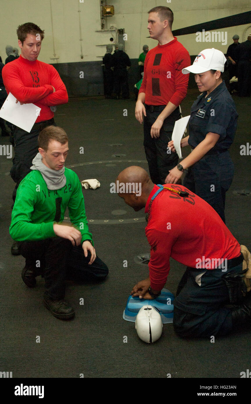 Sailors practice cardiopulmonary resuscitation (CPR) on a training ...
