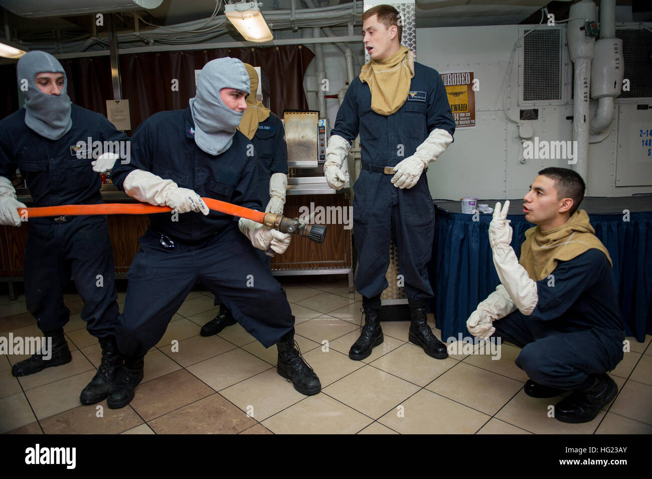 Damage Controlman Fireman Christian Ramirez, right, coaches a Sailor on ...