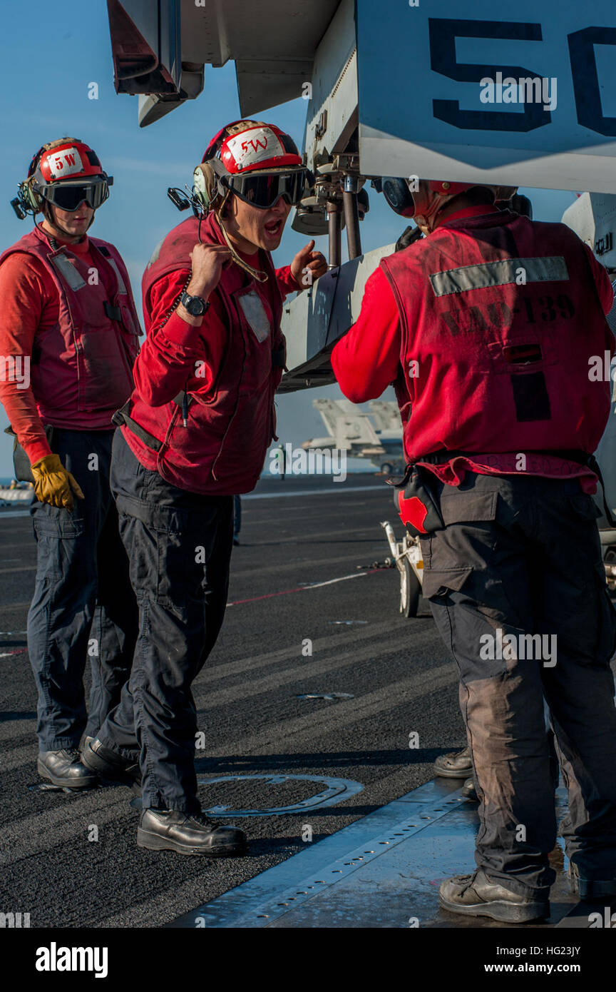 Aviation Ordnanceman 2nd Class Cody Askew, center, shouts instructions ...