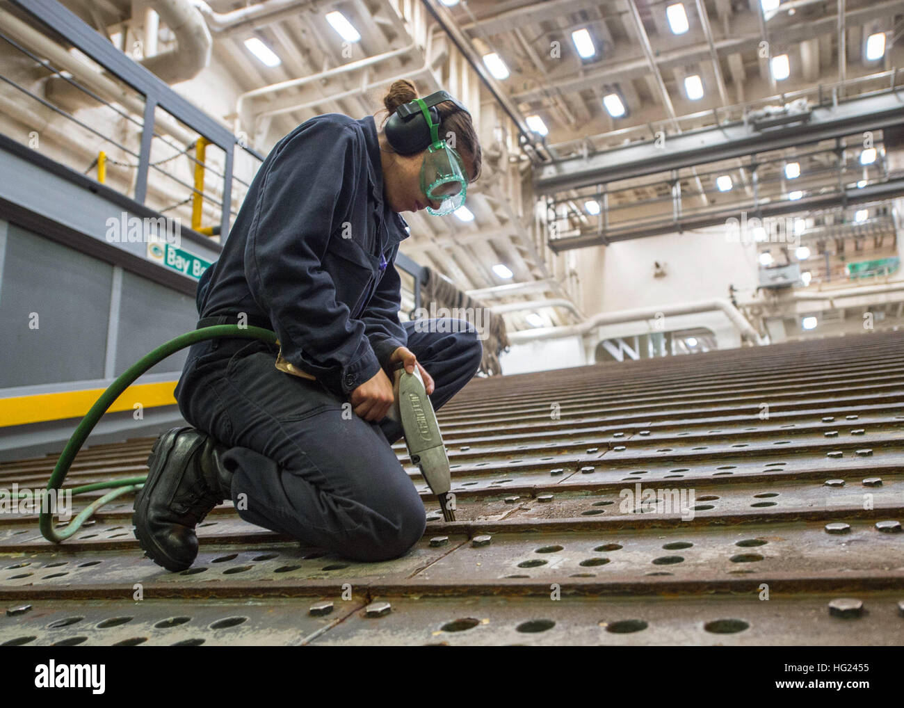 Boatswain's Mate Seaman Sarah Lecuyer uses a needle gun to chip paint ...