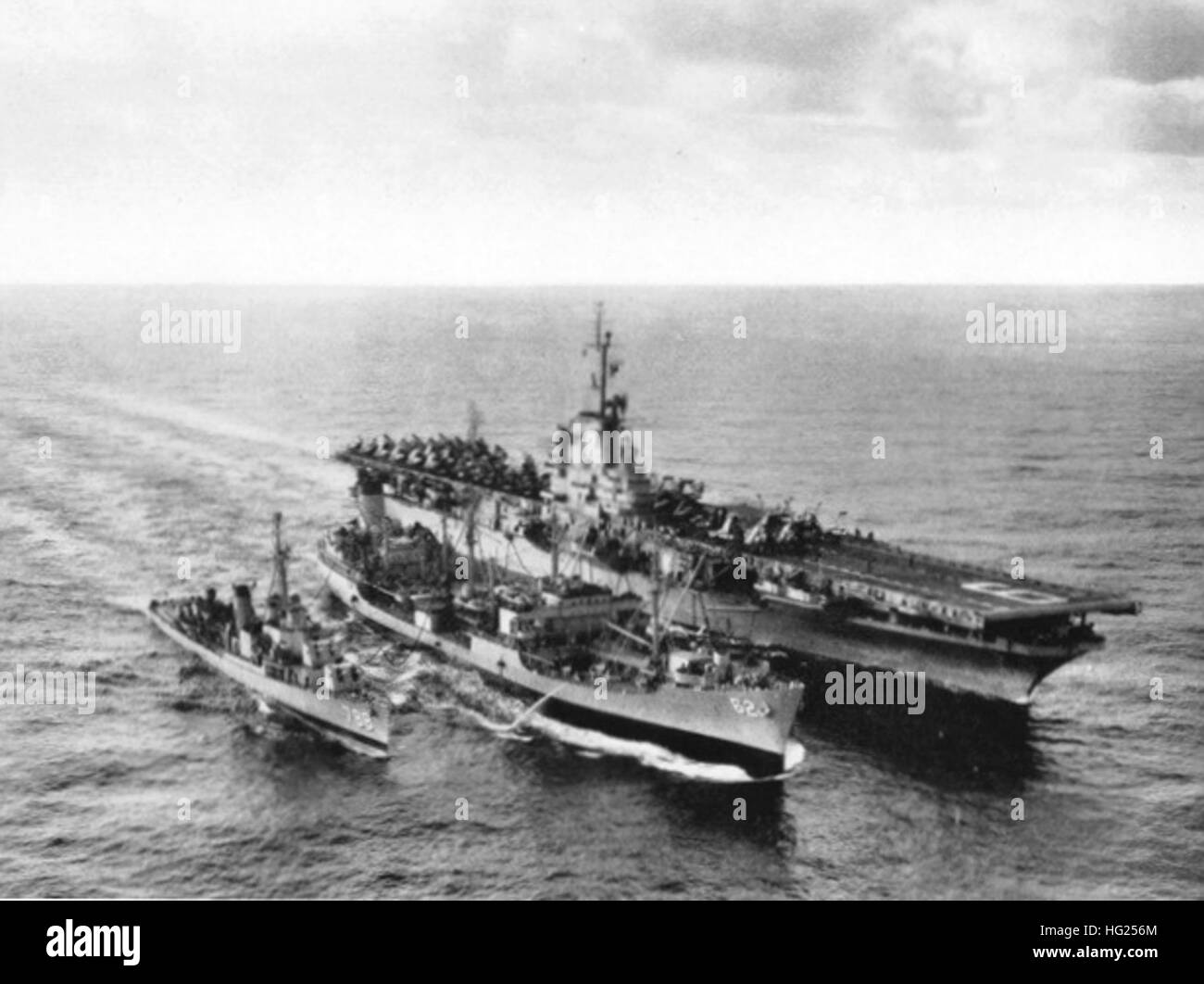 USS Taluga (AO-62) refueling USS Essex (CVA-9) and USS Hollister (DD ...