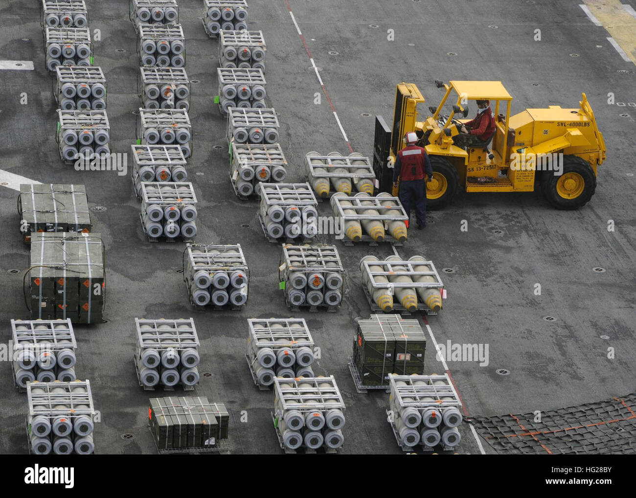 Sailors arrange ammunition pallets on the flight deck of the amphibious ...