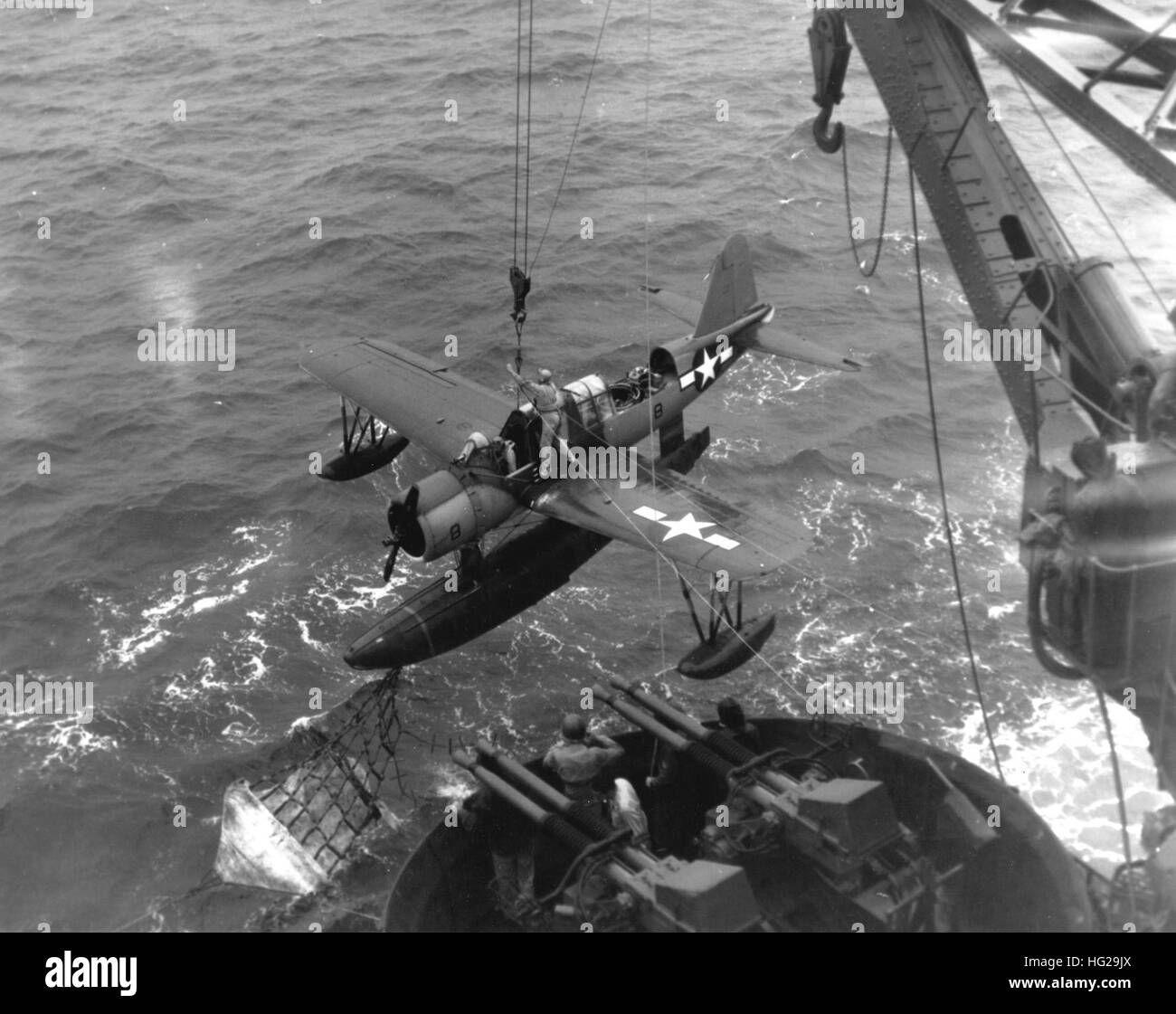 USS Texas (BB-35) recovers a Vought OS2U Kingfisher floatplane in a ...