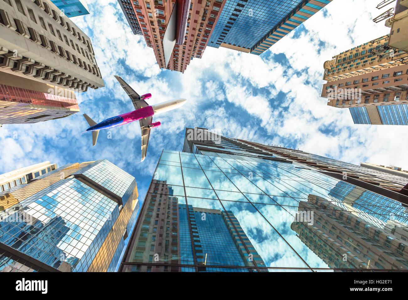 Airplane flying over skyscrapers Stock Photo - Alamy
