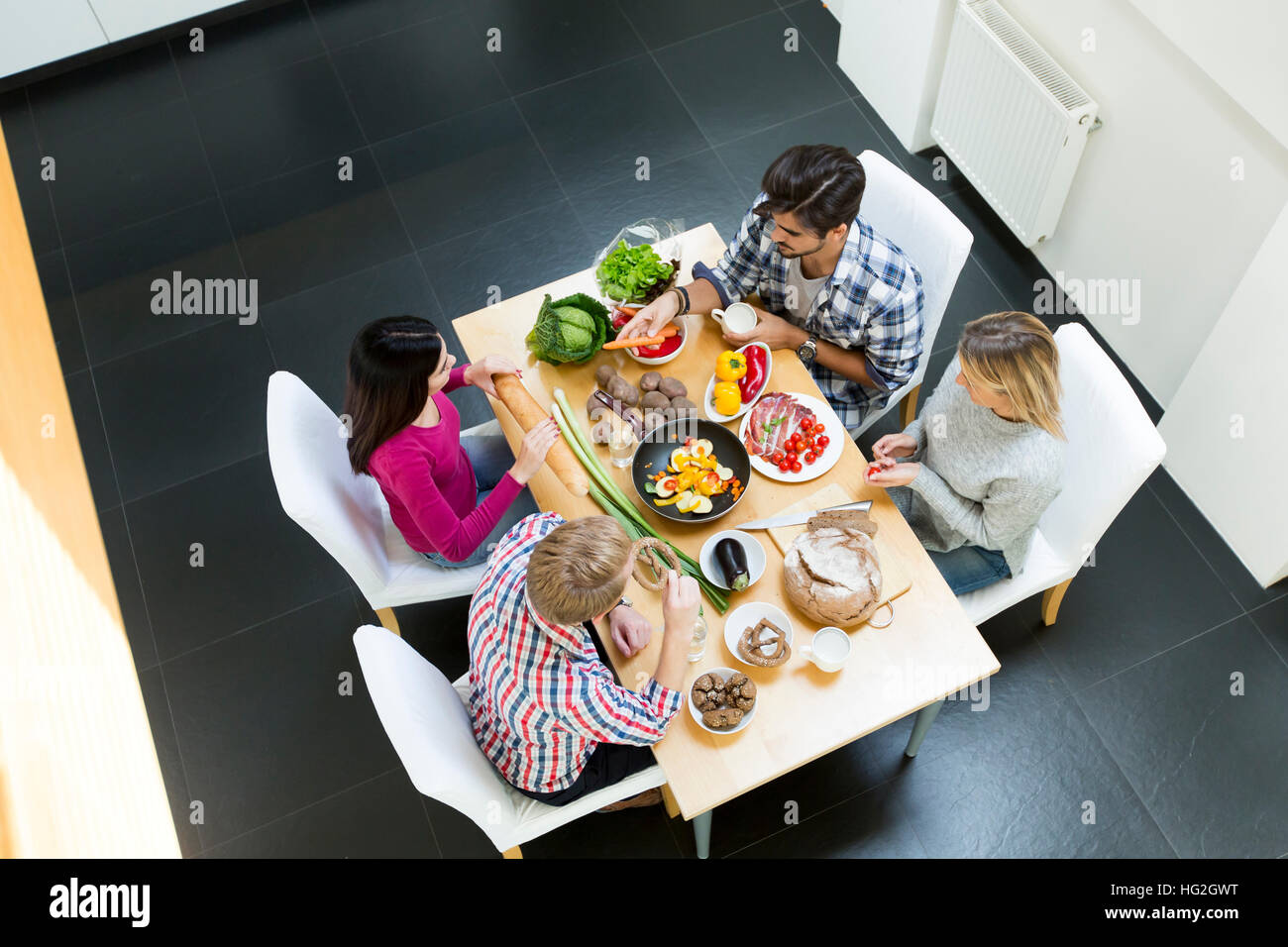 Group of young people having meal in the modern kitchen Stock Photo - Alamy