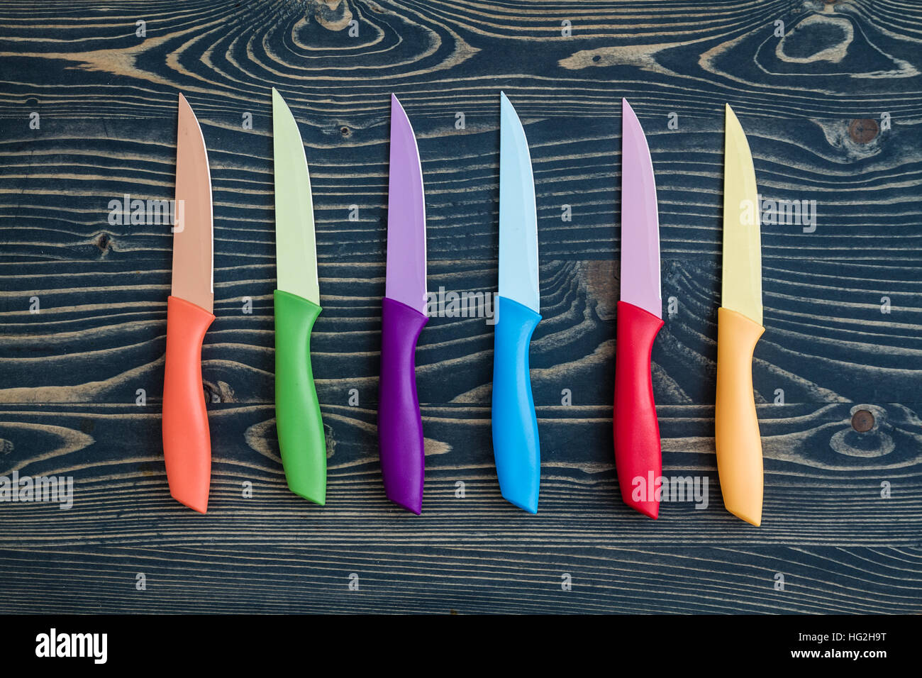 Set of Colorful Kitchen Knives over blue wooden background Stock Photo ...