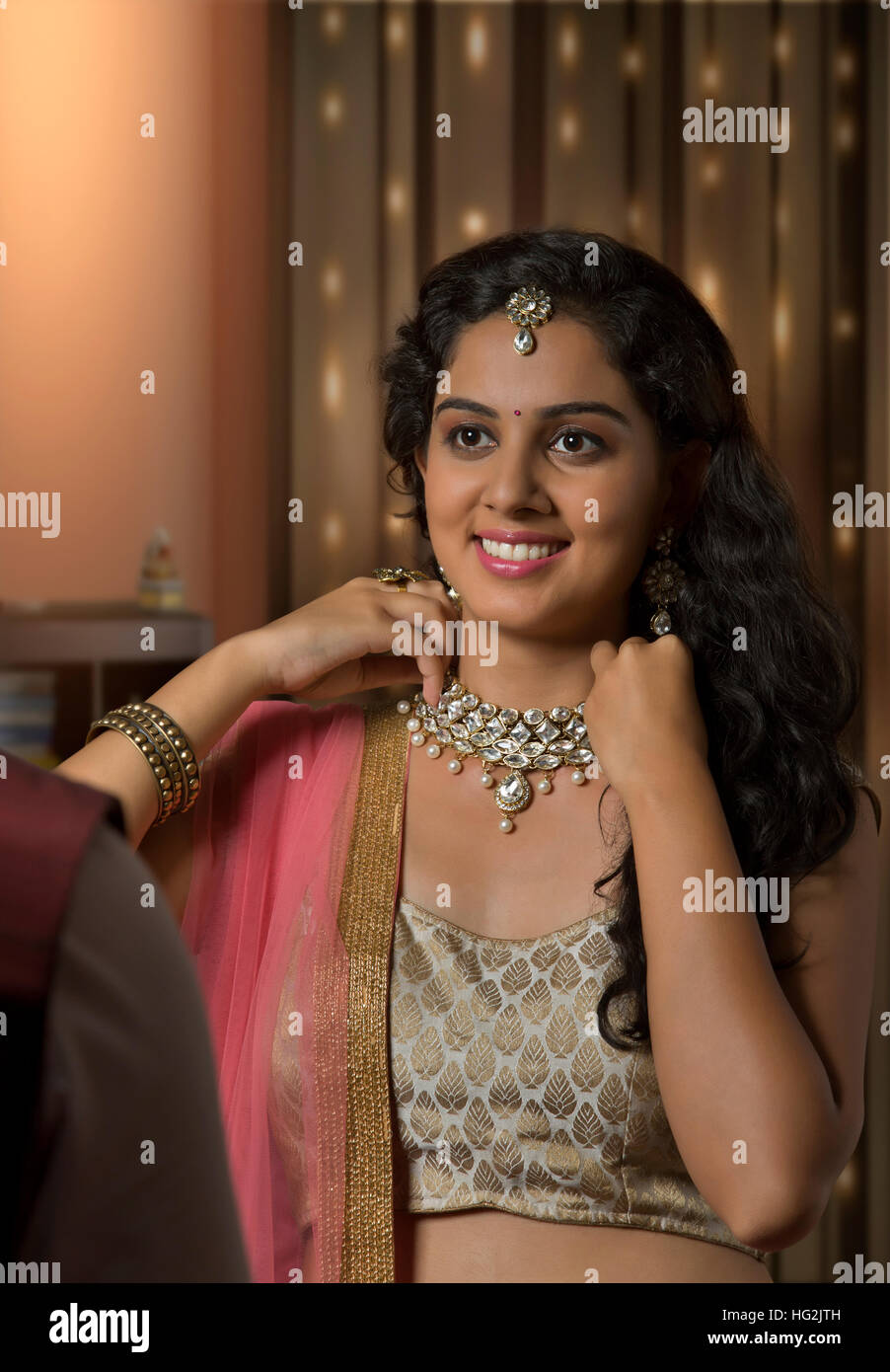 Smiling Young woman trying on necklace Stock Photo - Alamy