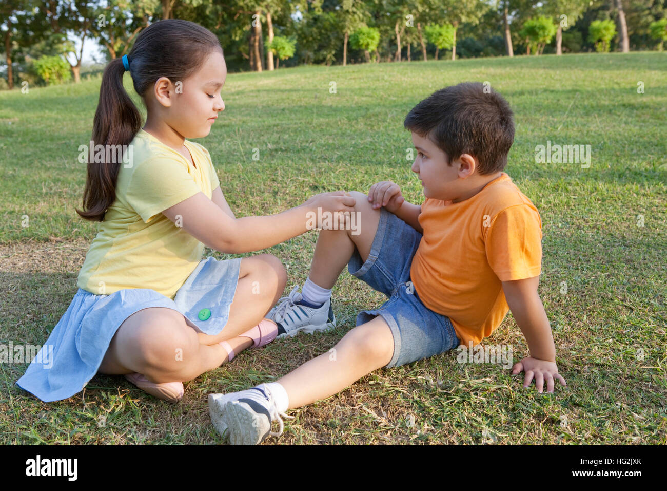 Girl putting band-aid on brothers leg Stock Photo - Alamy