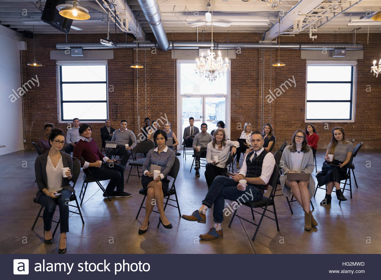 Portrait confident business people sitting in chairs in conference room ...