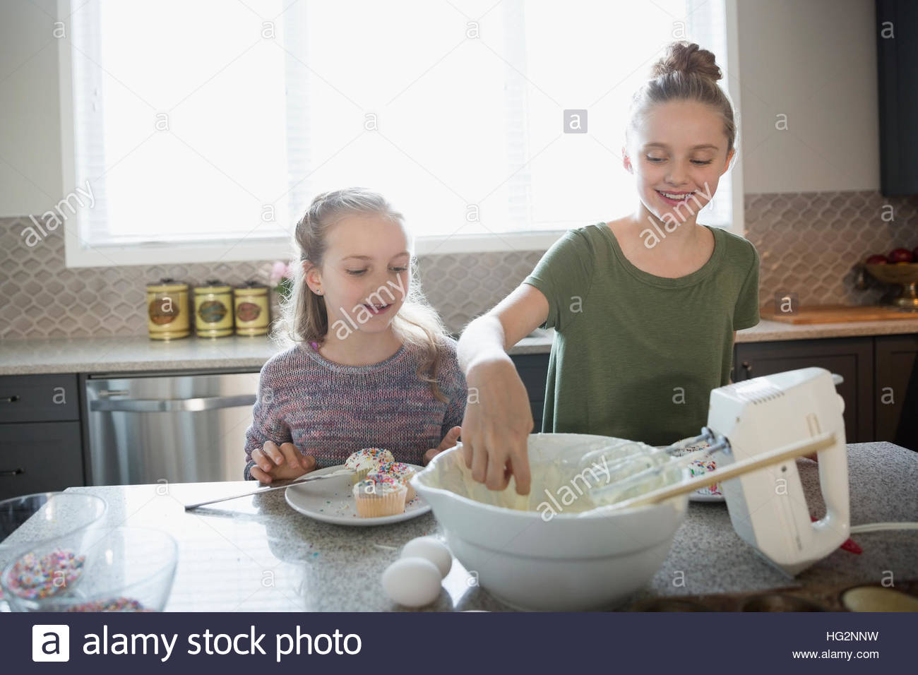 Sisters baking in kitchen frosting cupcakes Stock Photo - Alamy