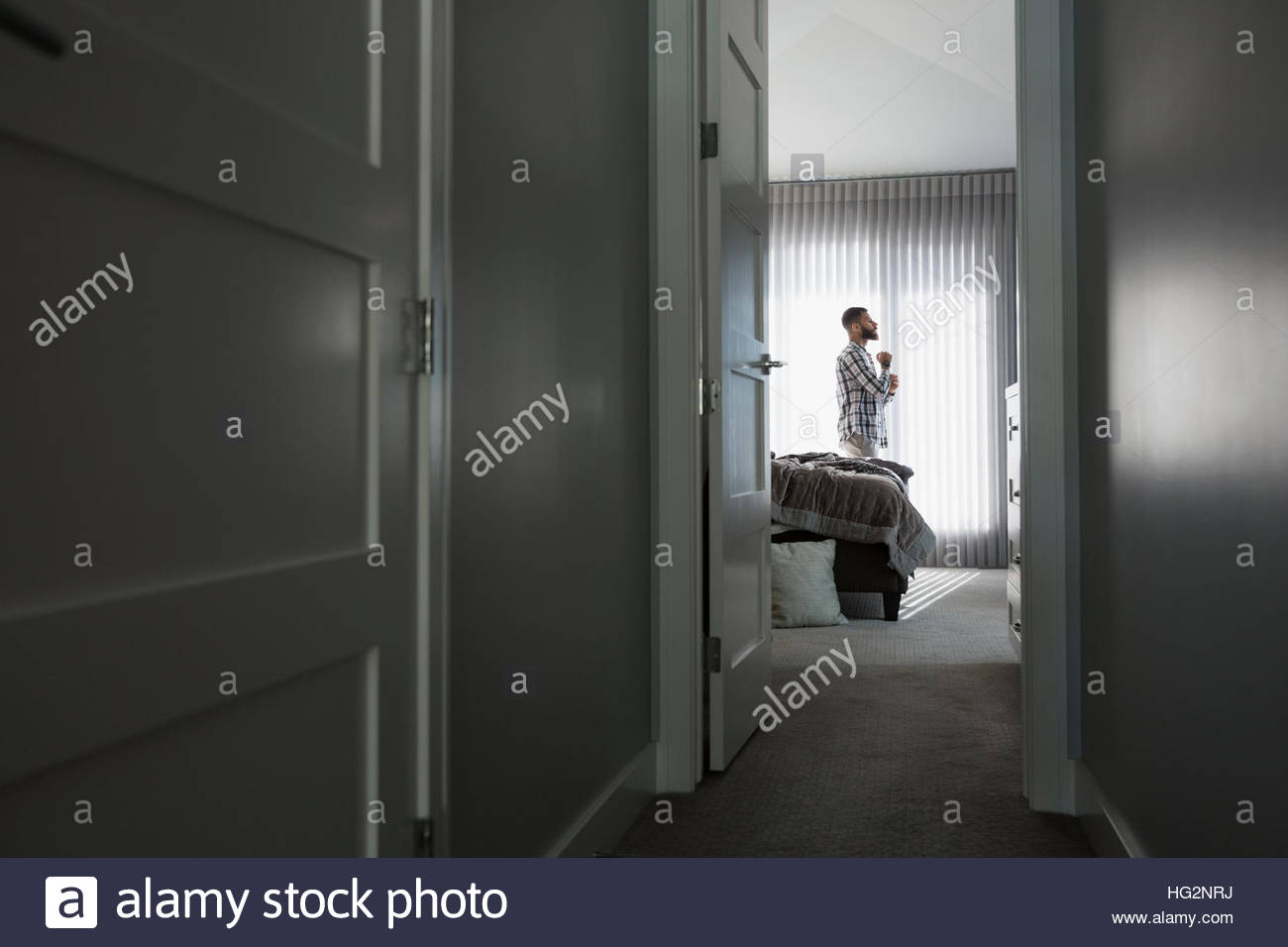 Man getting dressed in bedroom Stock Photo - Alamy
