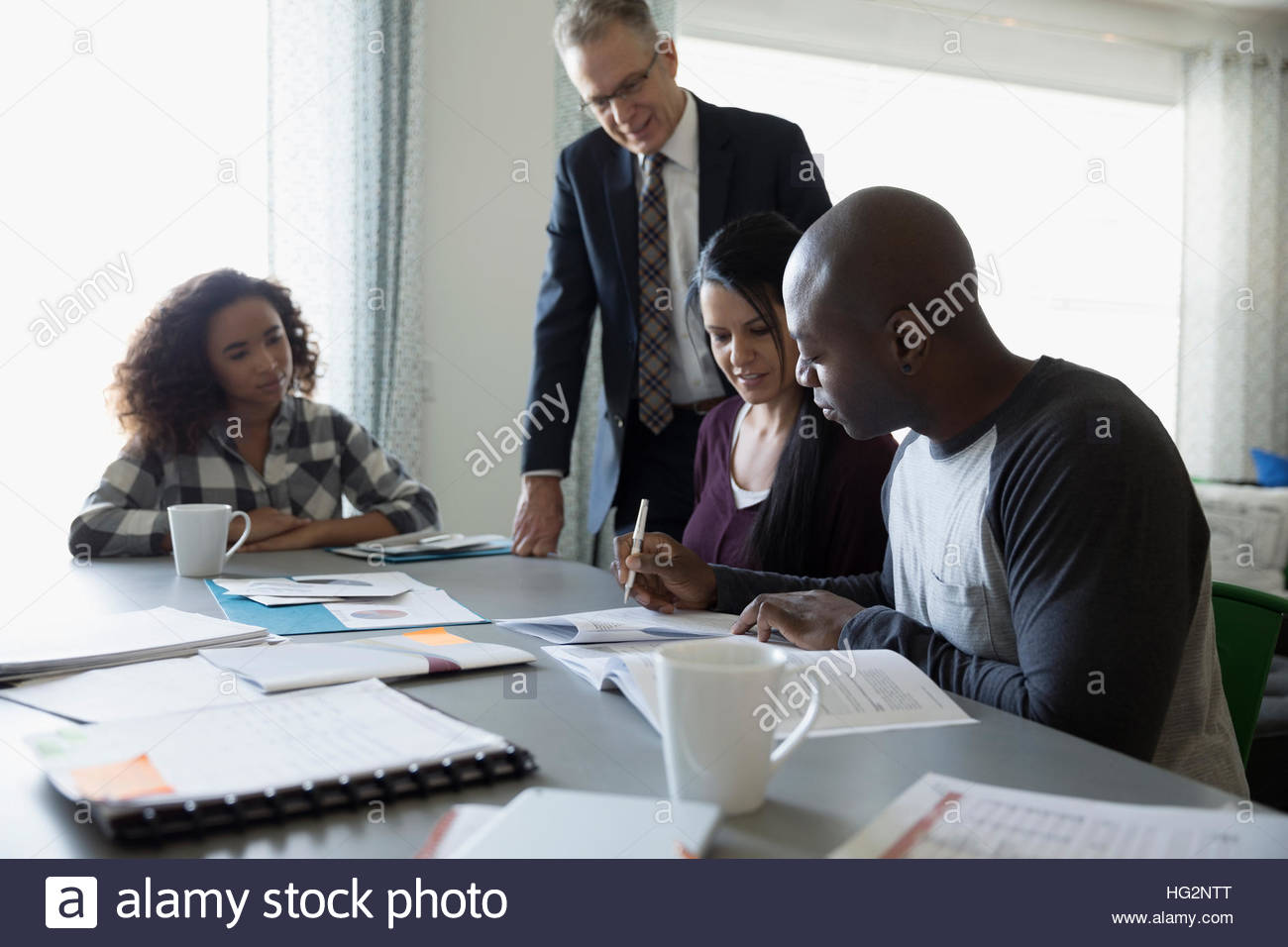 Financial advisor with paperwork meeting with family at dining room ...