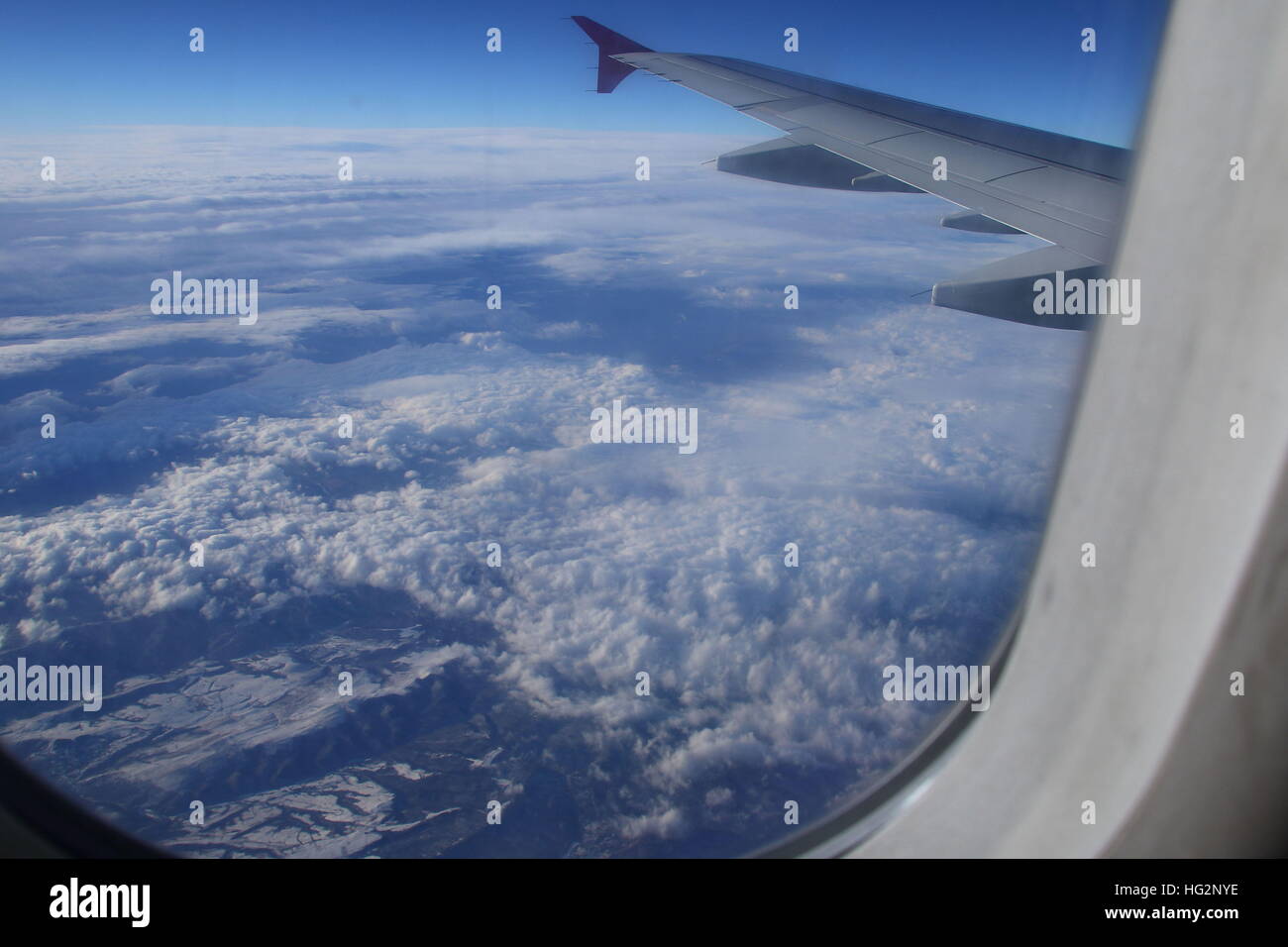 View from aircraft window while flying high above the clouds image with ...