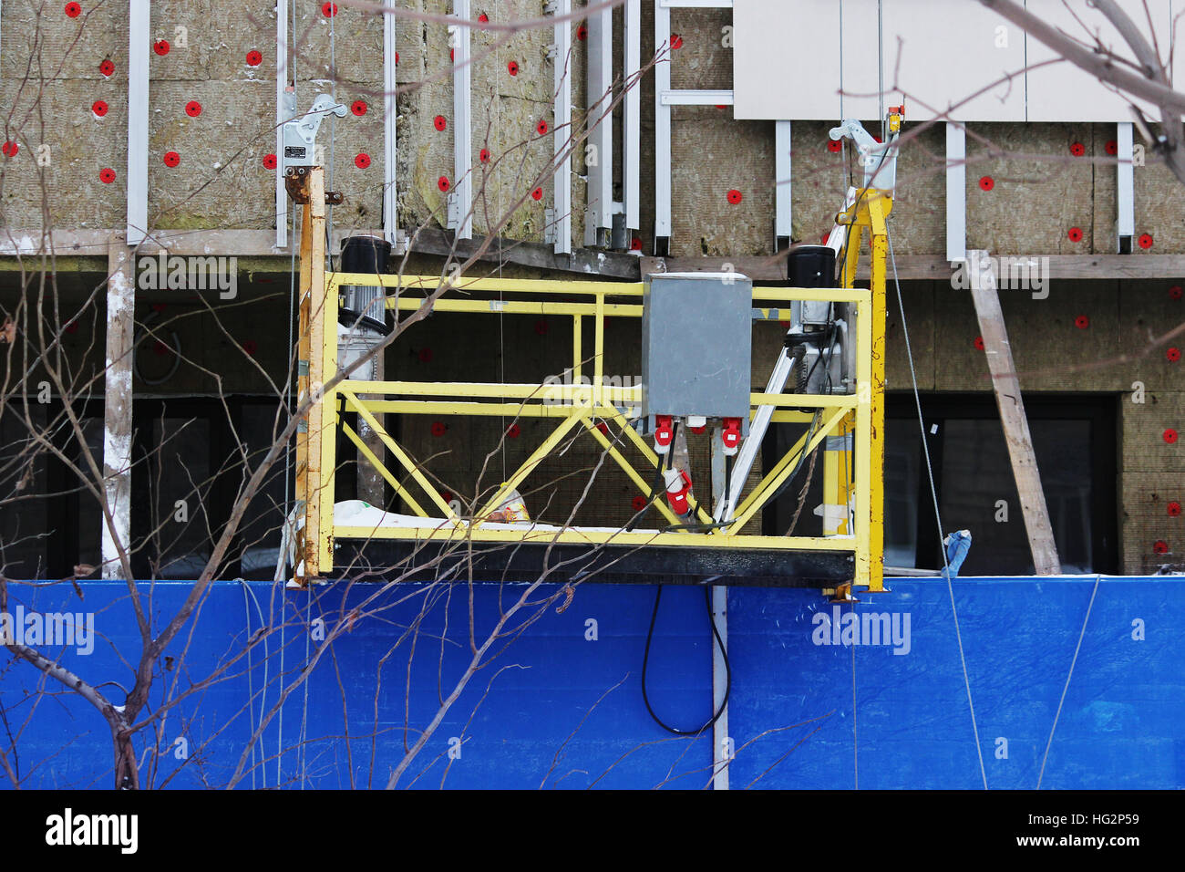 construction suspended yellow cradle without workers on a newly built ...